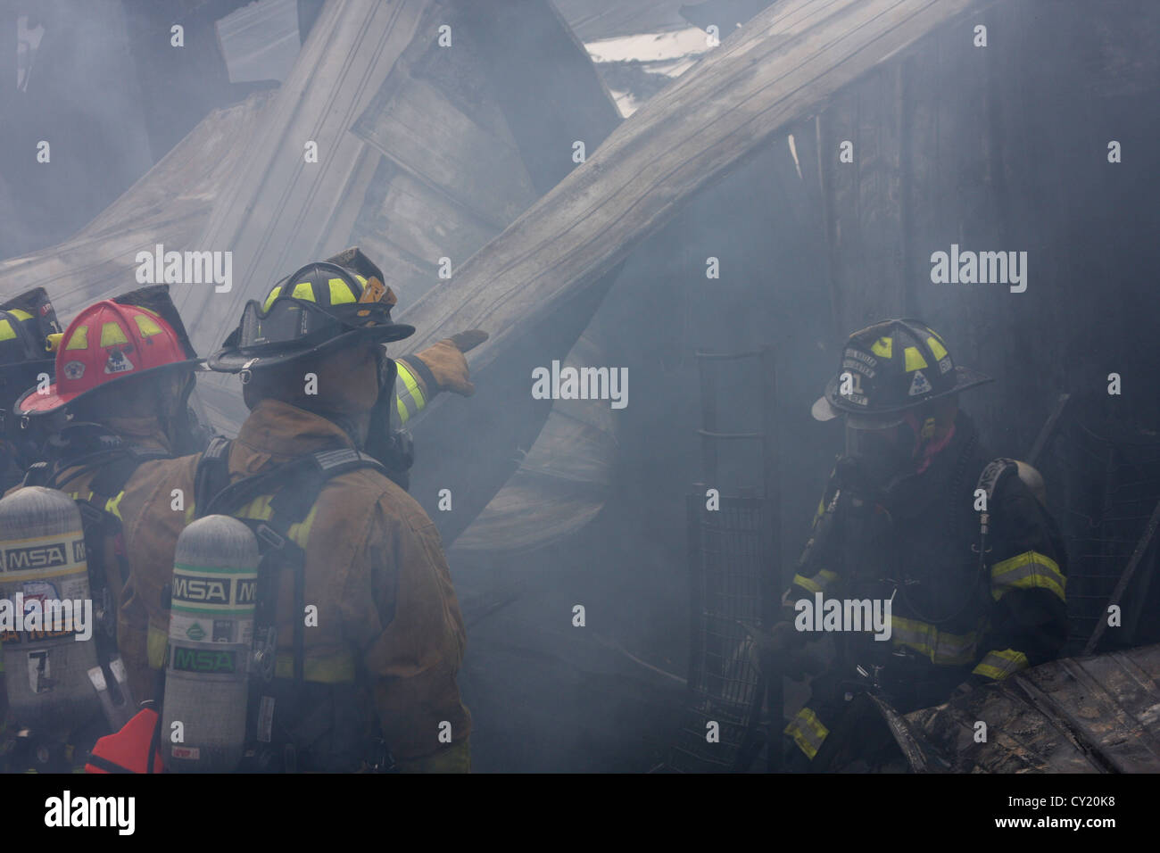 Firefighters pointing at the debris from a roof collapse Stock Photo ...