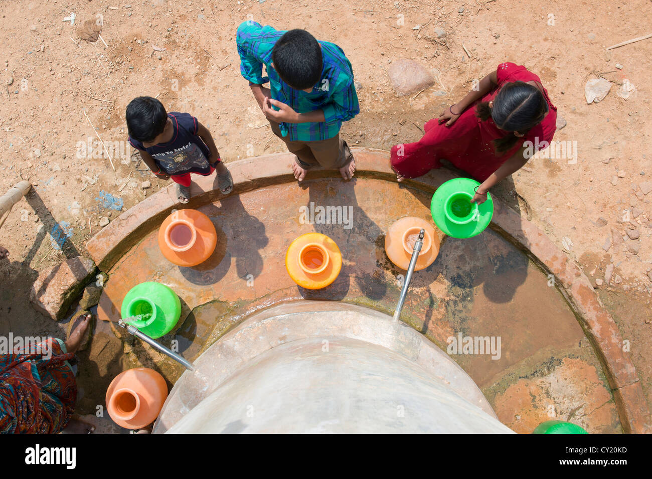 Rural Indian village children collecting water from a communal water ...