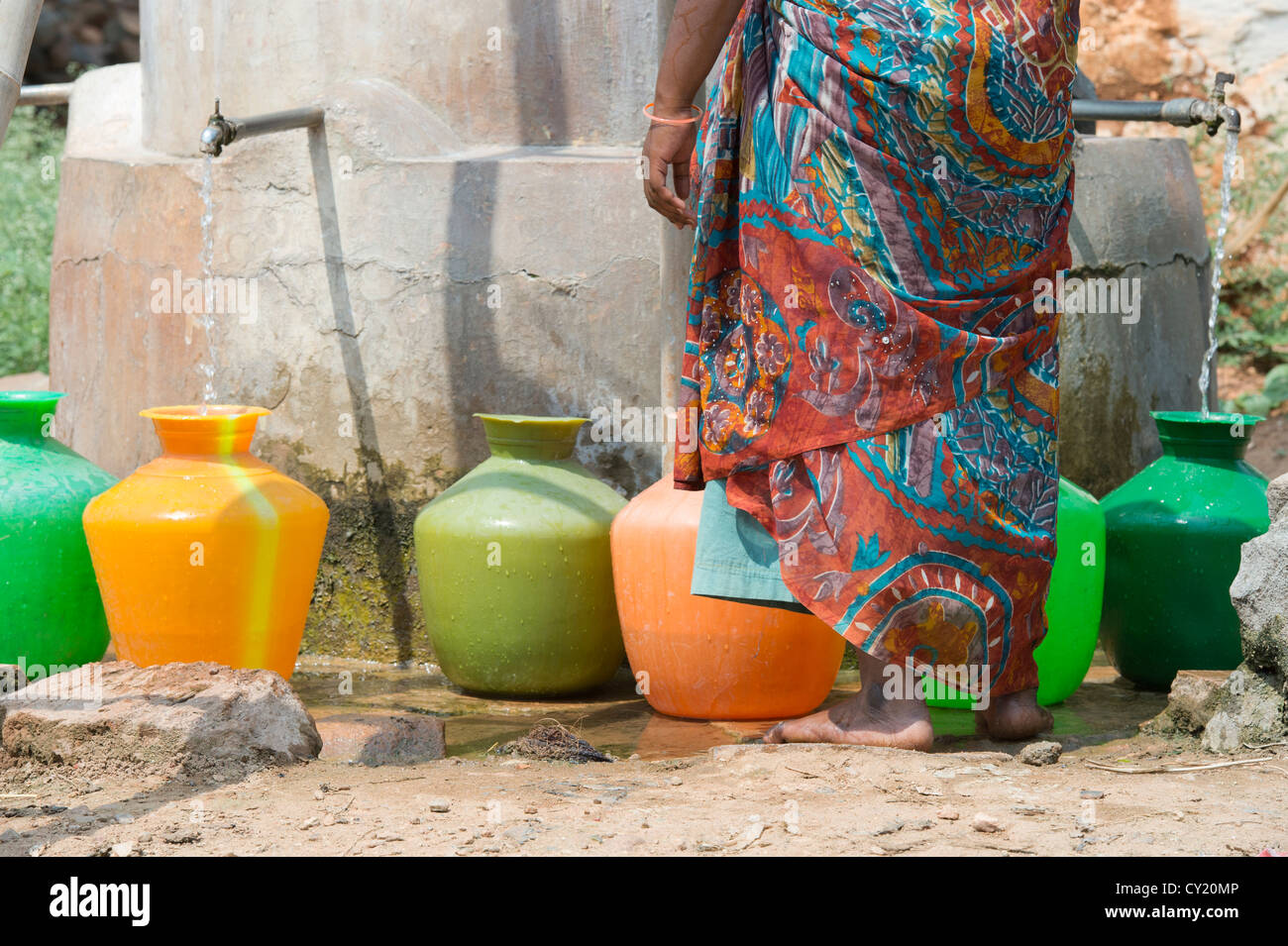 Rural Indian village woman collecting water from a communal water tank ...