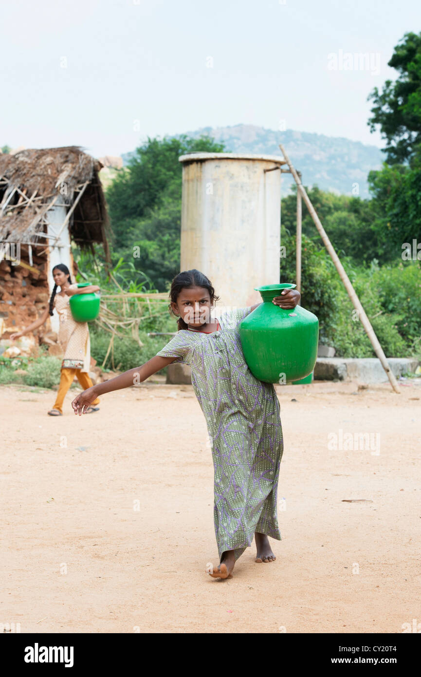 Young rural Indian village girl collecting water from a communal water ...