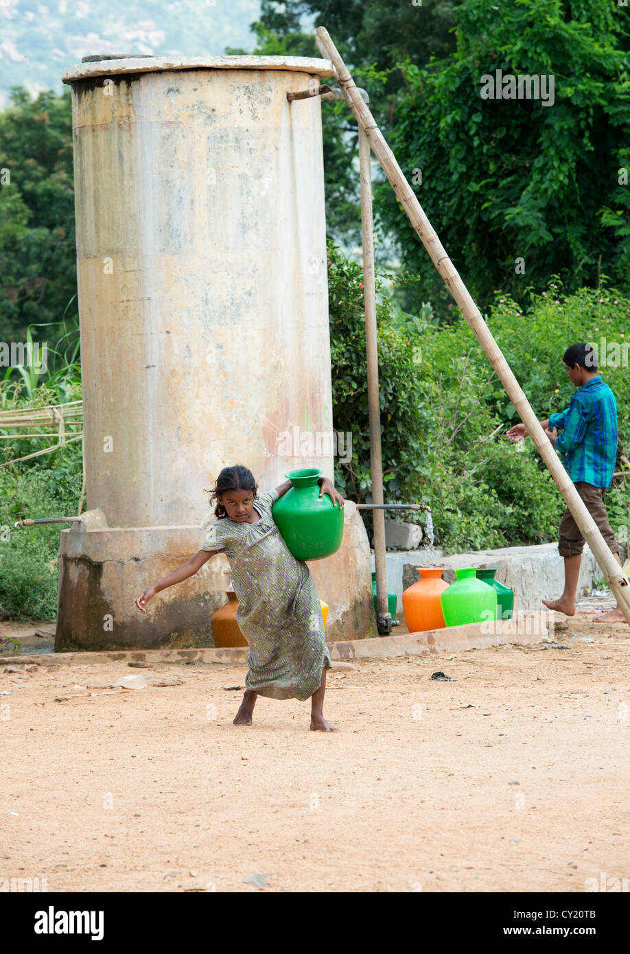 Young rural Indian village girl collecting water from a communal water ...
