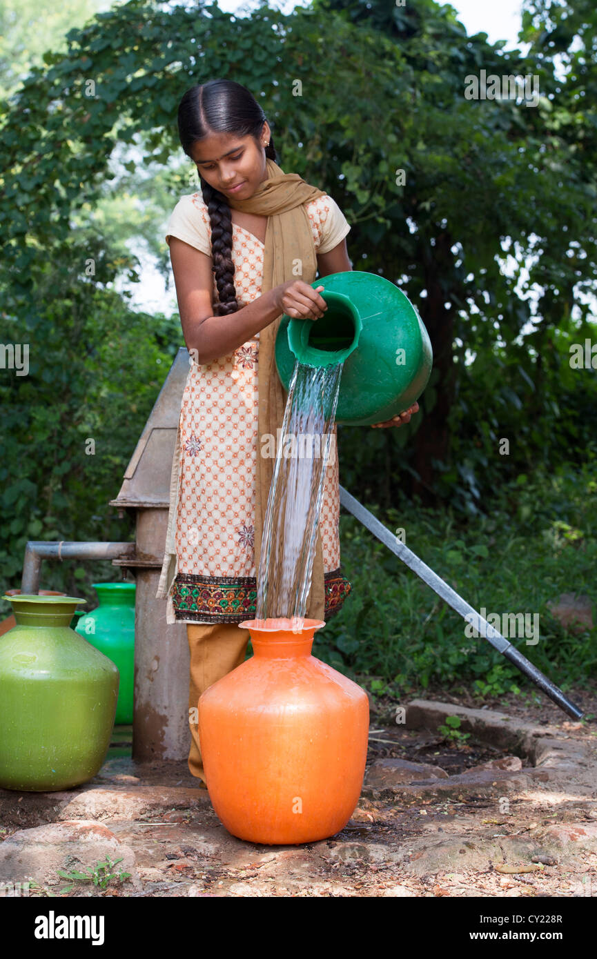 Rural Indian Village Girl Filling Water Pots From A Communal Water Pump