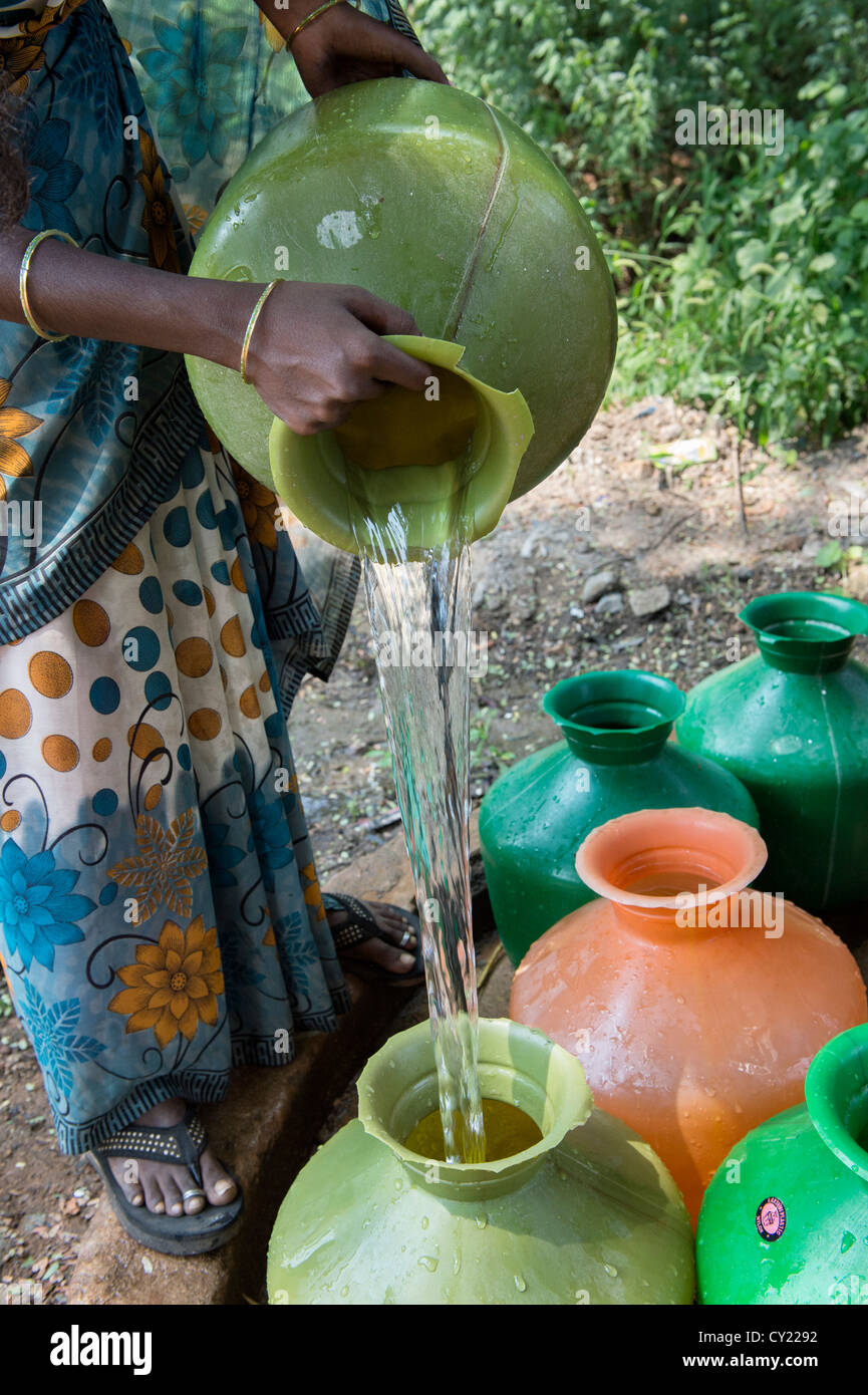 Rural Indian village woman filling water pots from a communal water ...