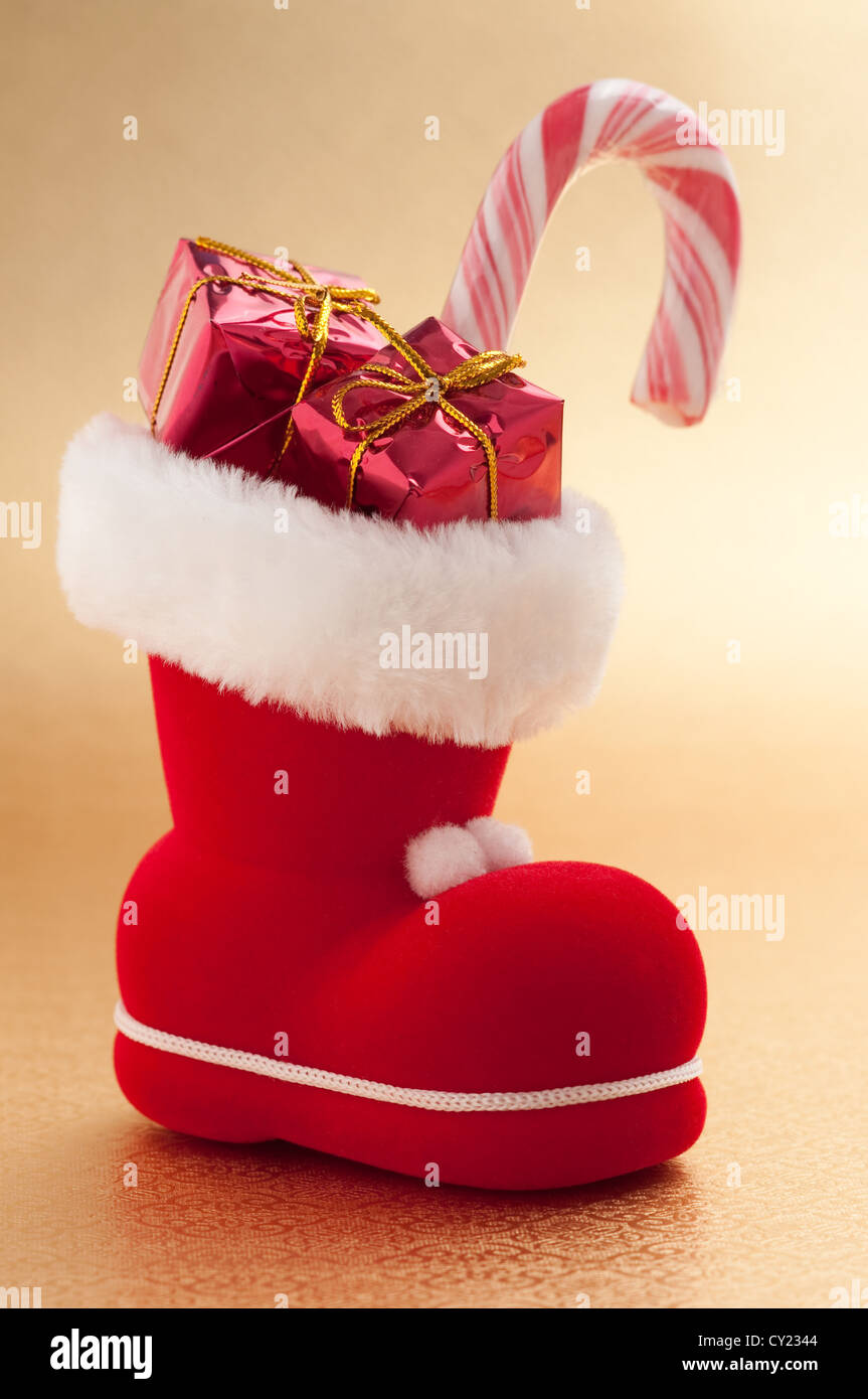 red christmas boot with gifts on gold background Stock Photo - Alamy