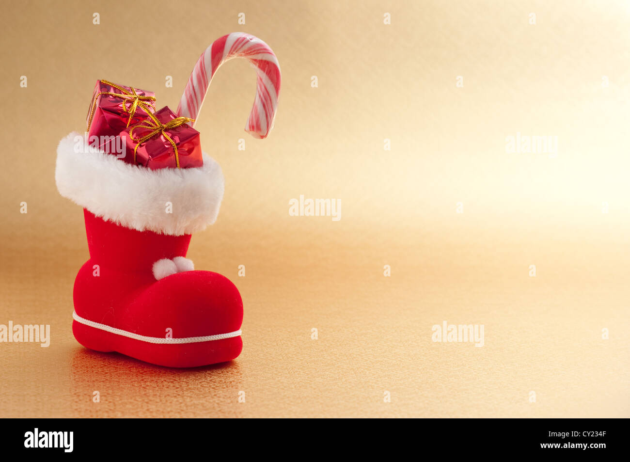 red christmas boot with gifts on gold background Stock Photo - Alamy