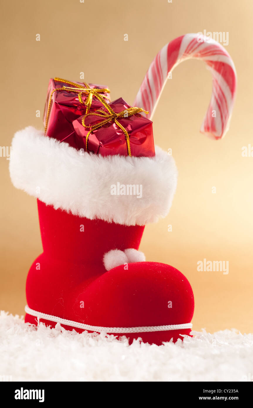 red christmas boot with gifts on gold background Stock Photo - Alamy