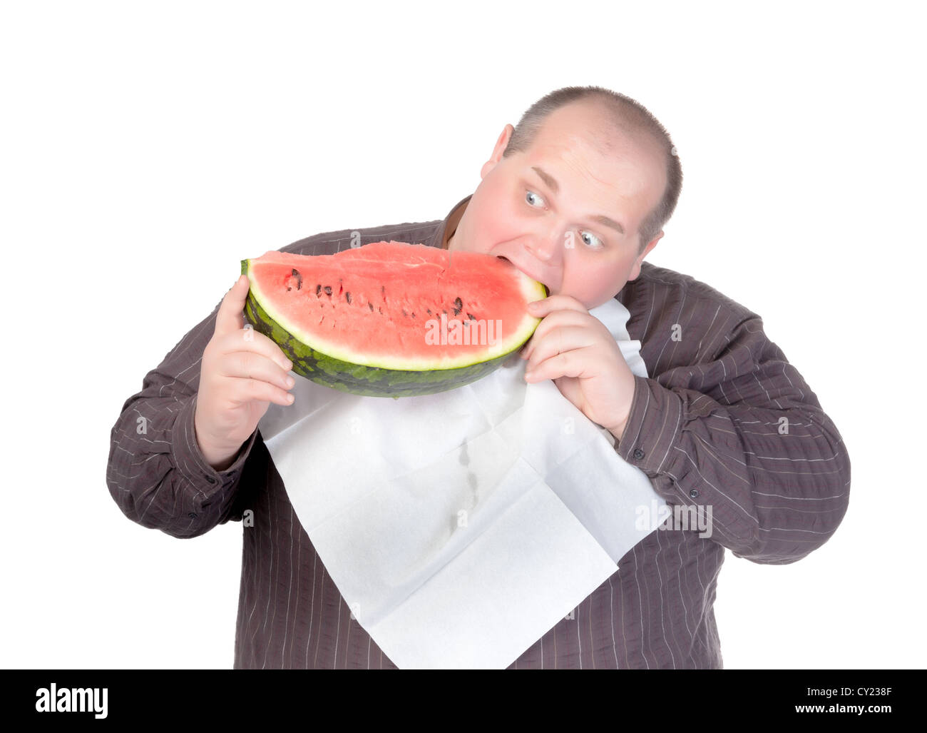Obese man with a serviette bib around his neck standing eating a large ...