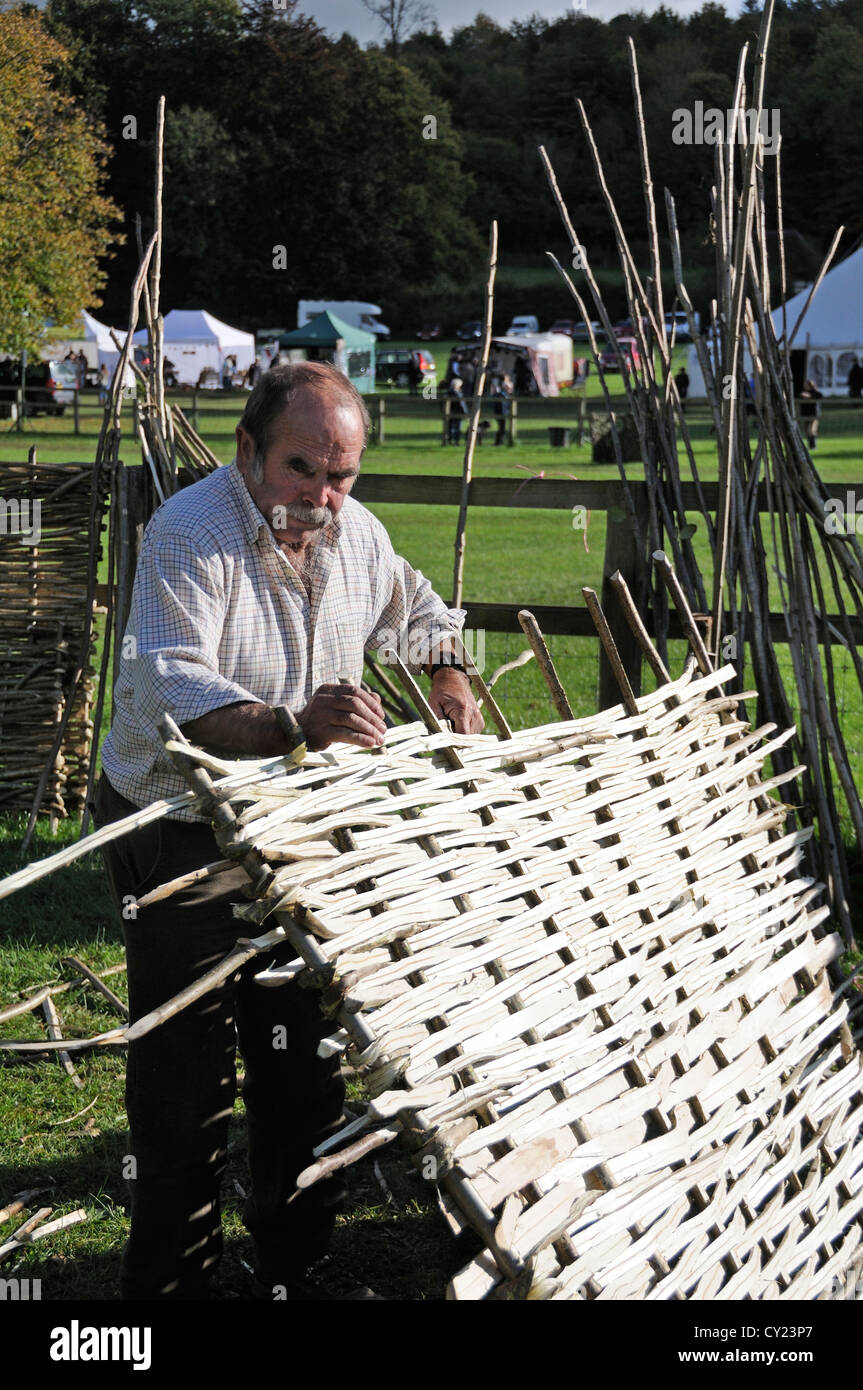 Hurdle maker threading split ash into a hurdle for sheep pens and ...