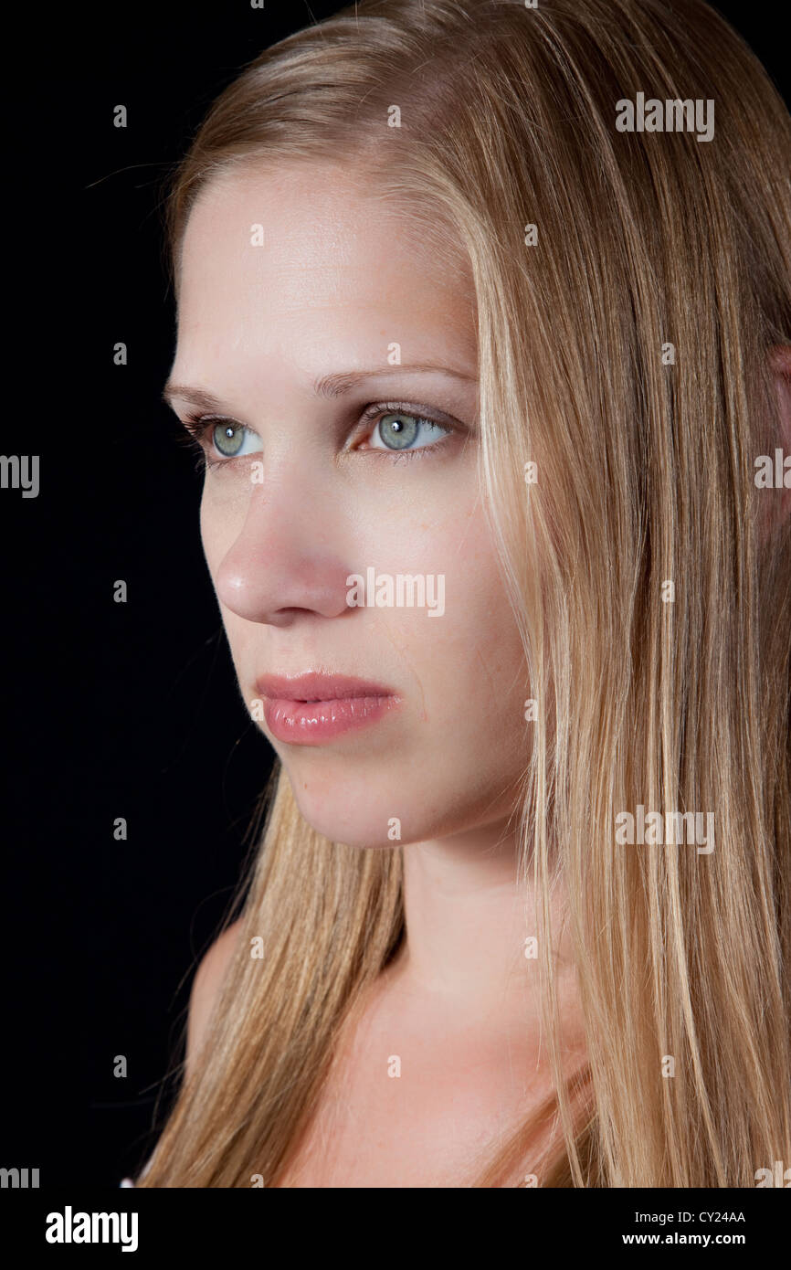 Pretty brunette woman in a striped dress, looking left with a serious ...