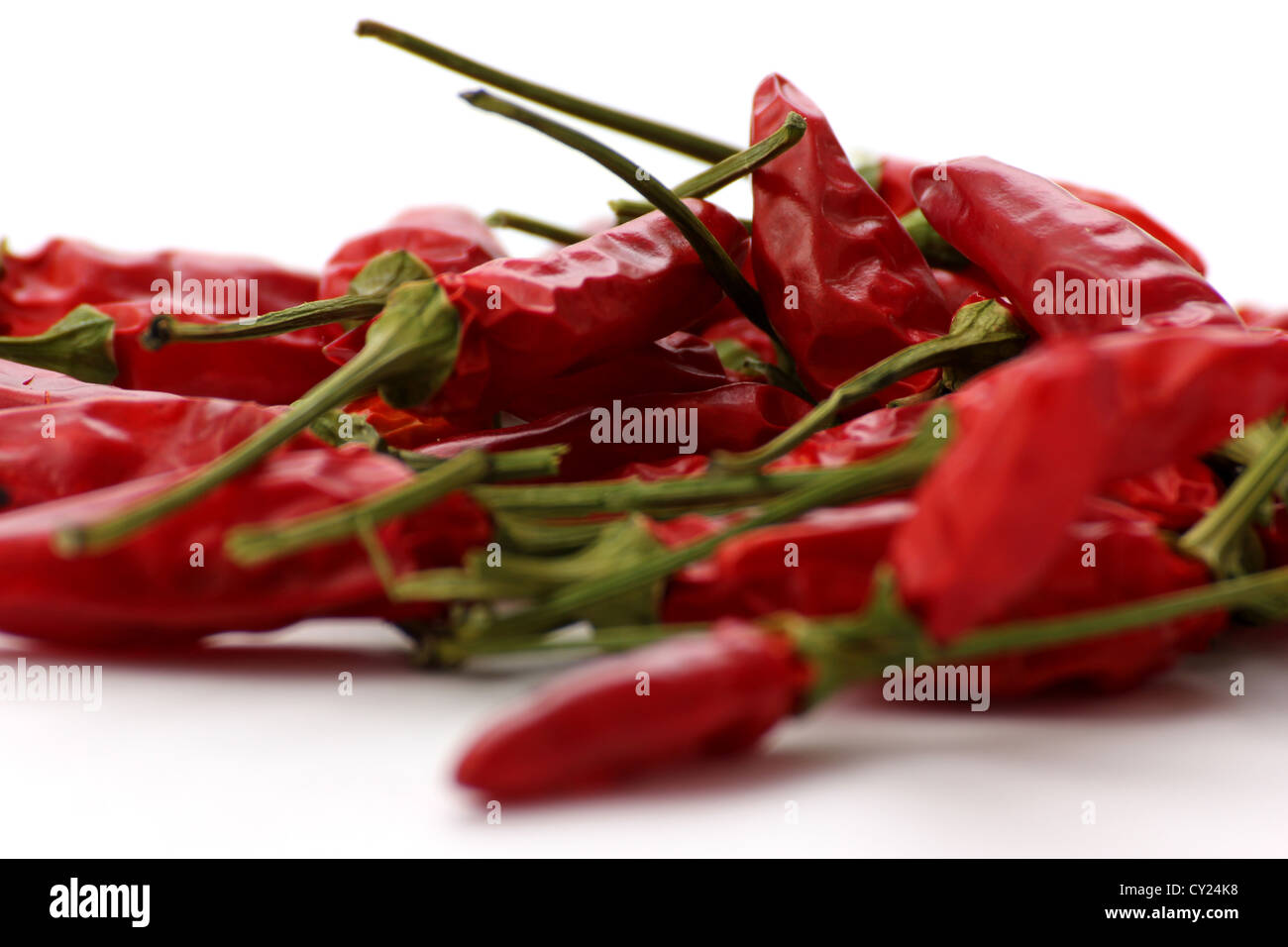a beautiful picture of various red peppers scattered against a white ...