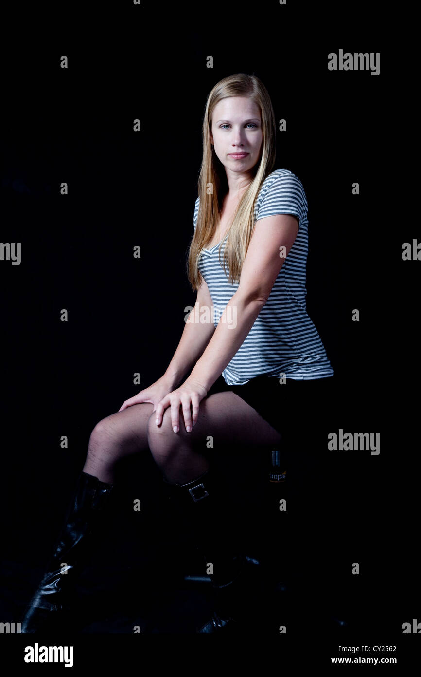 Pretty blond woman against a black background, with a sober and ...