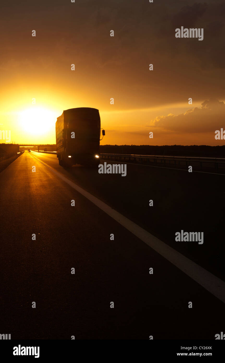 Truck traveling at sunset Stock Photo - Alamy