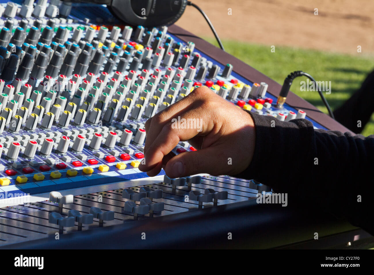 Man adjusting controls on a soundboard at an outdoor concert Stock ...