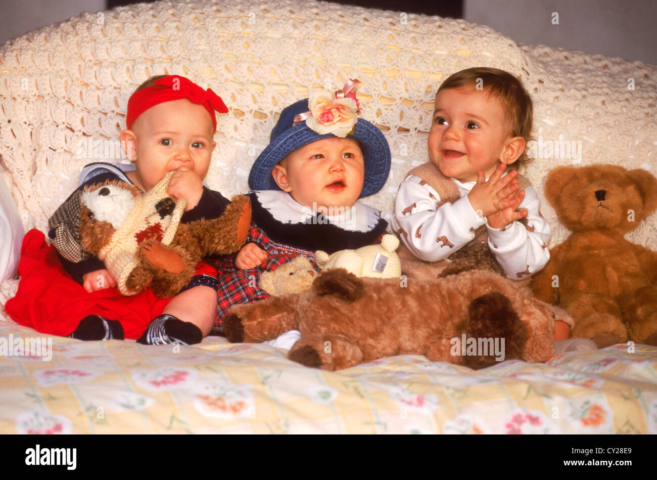Three babies on bed with their stuffed toys and teddy bear buddies ...
