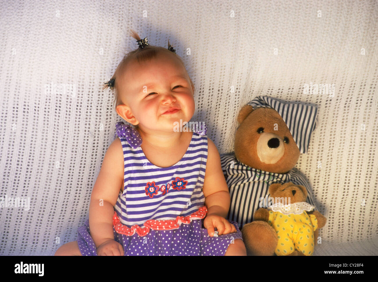Baby and her teddy bear buddies sharing bed together Stock Photo - Alamy