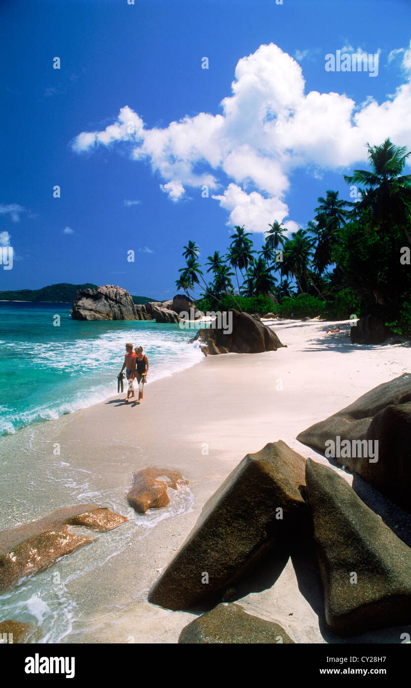 Couple alone in paradise on La Digue Island amid sand, waves, granite ...