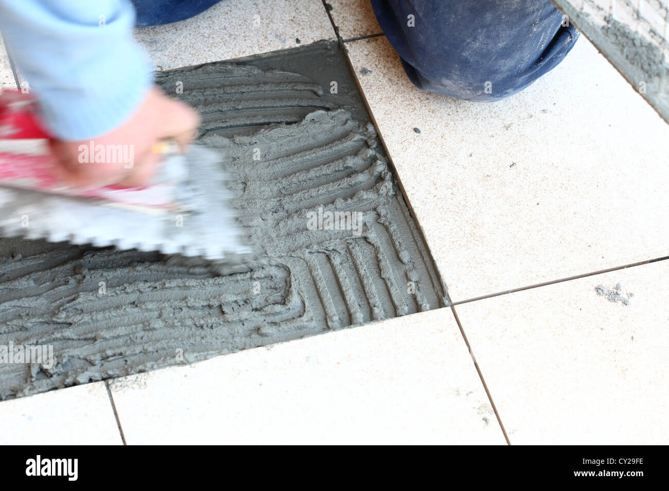 Man Construction worker is tiling at home Stock Photo - Alamy