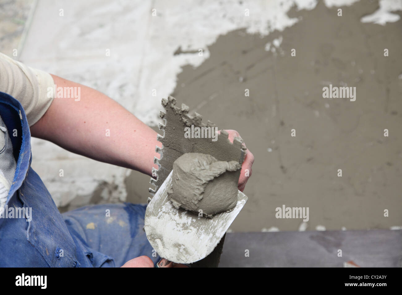 Construction worker is tiling at home tile floor adhesive Stock Photo ...