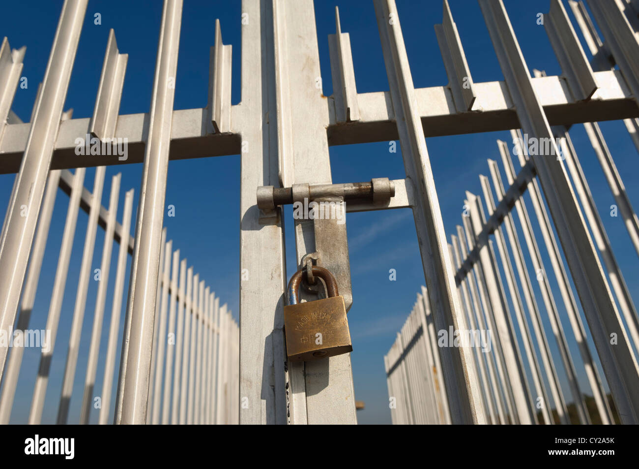 Iron gate padlocked against the blue sky Stock Photo - Alamy