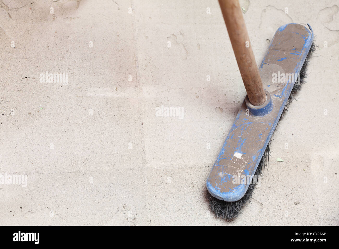 rough concrete at a job site using a large blue broom Stock Photo - Alamy