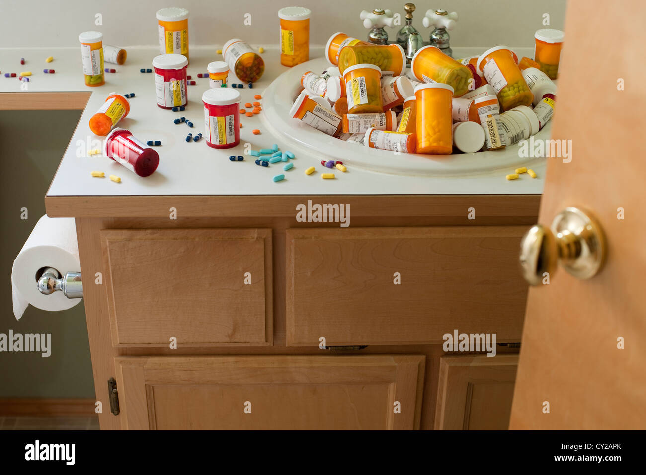 Pills and pill bottles scattered over sink counter and in sink in ...