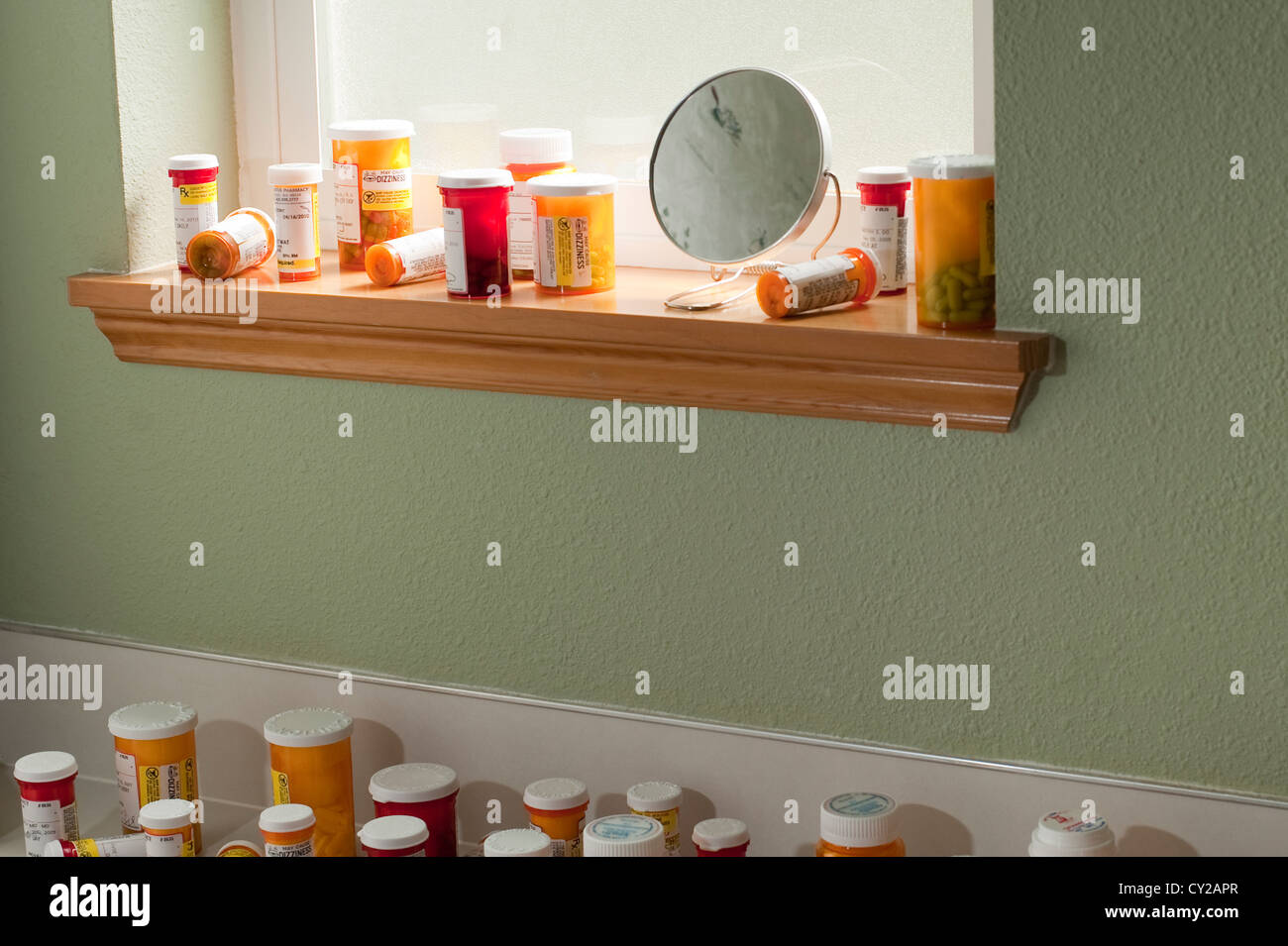 Pills and pill bottles along window sill with mirror and pills on ...