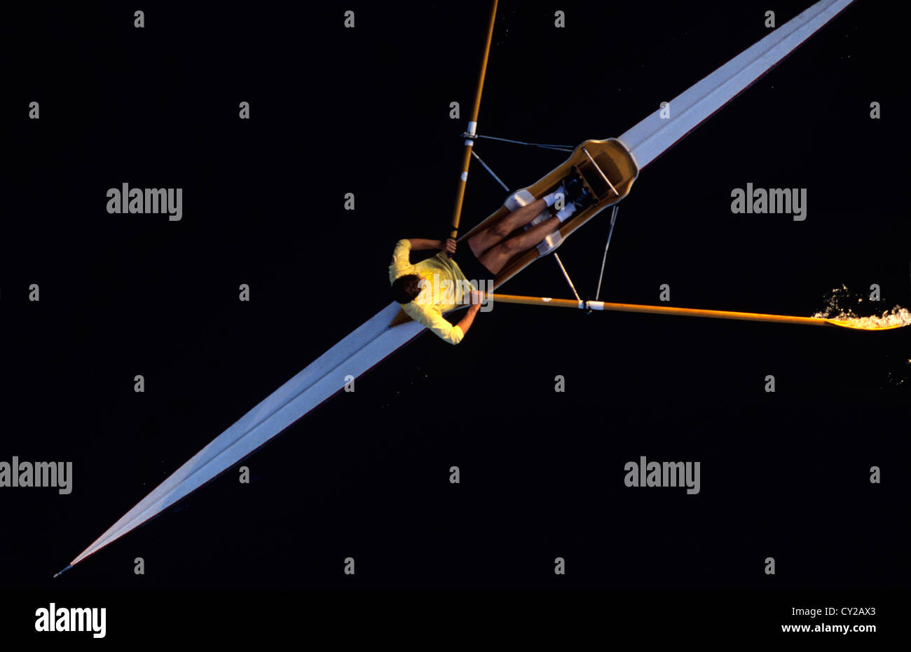 One crewman rowing on Montlake Cut with oars in the water sunrise ...