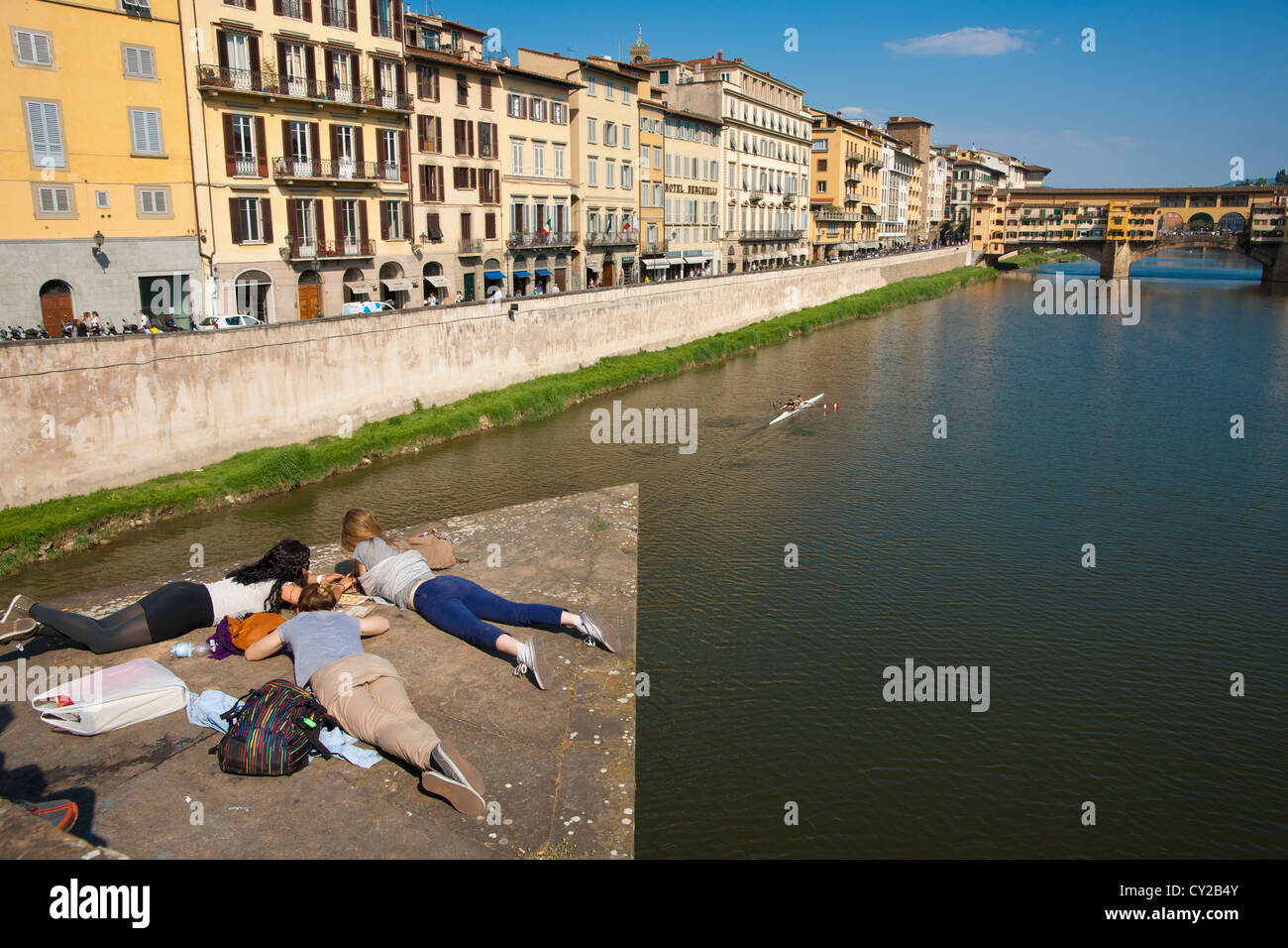 Students in view of Ponte Vecchio sunbathe on bridge buttress over the ...