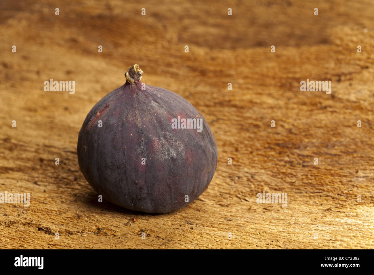 One whole fig on old tree bark as background Stock Photo - Alamy