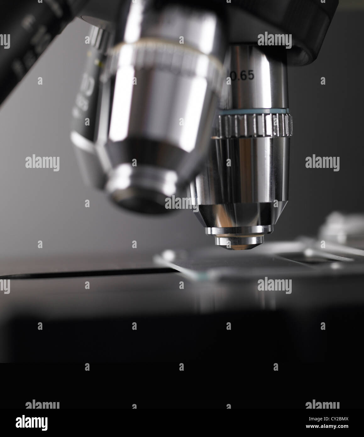 Lenses on the turret of a research microscope with glass slide on stage ...