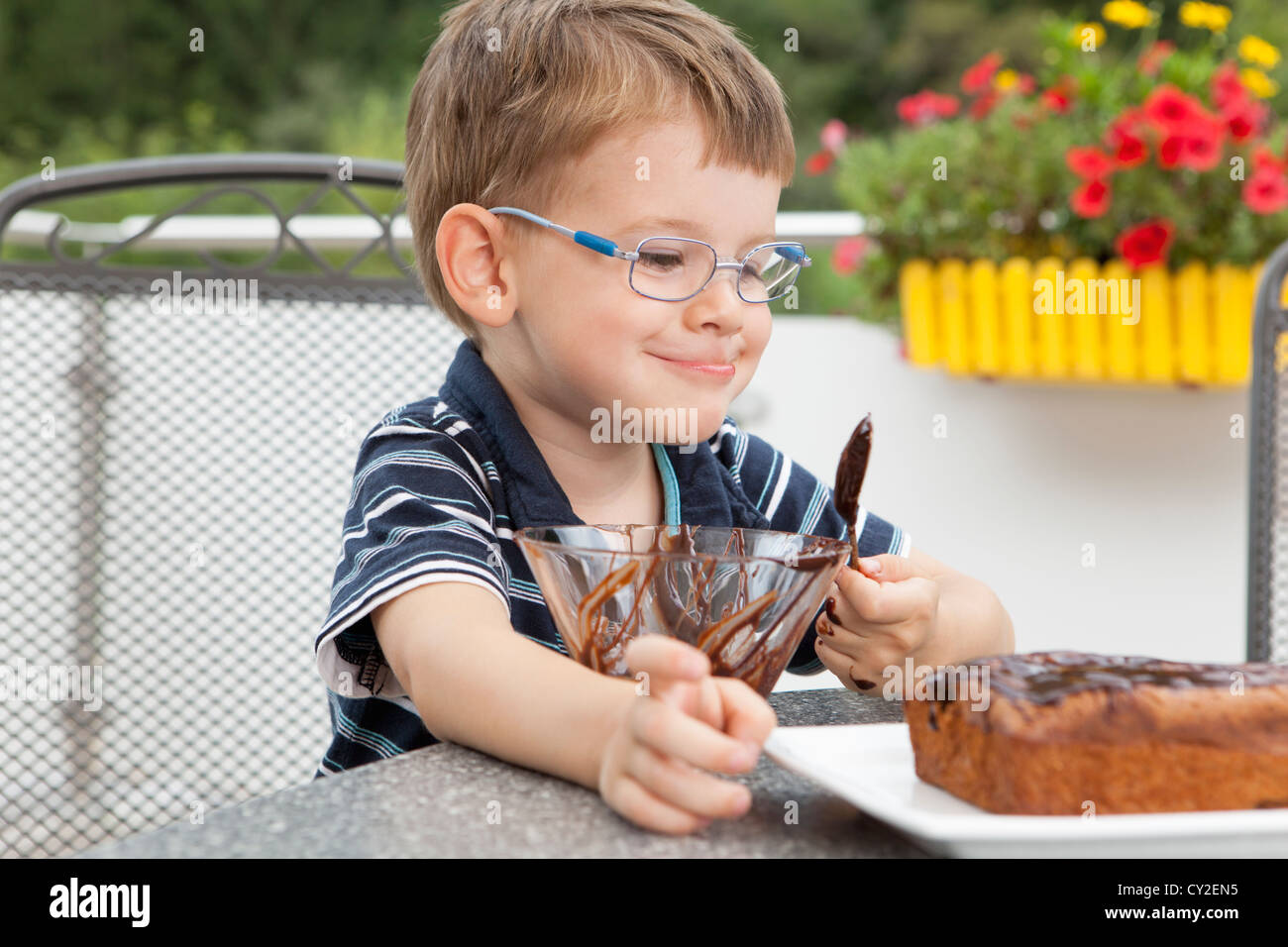 Little boy decorating the chocolate cake Stock Photo - Alamy