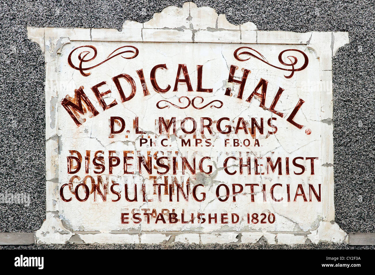 An old painted advertising sign on a wall announcing a dispensing ...