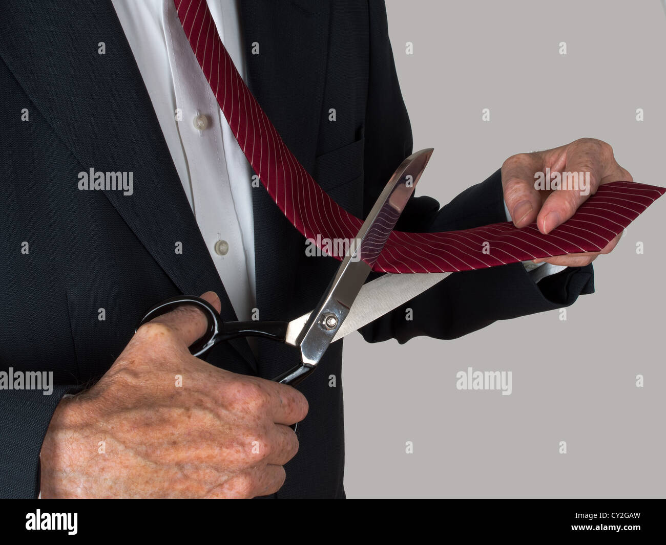 Quitting business - man cutting own tie Stock Photo - Alamy