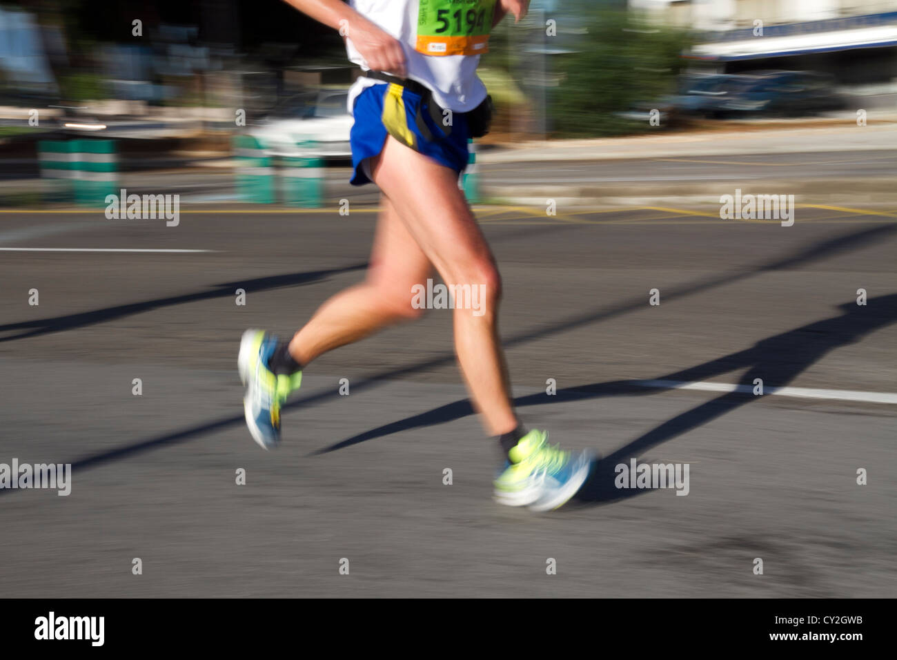 Marathon runner legs athlete running on road Stock Photo - Alamy