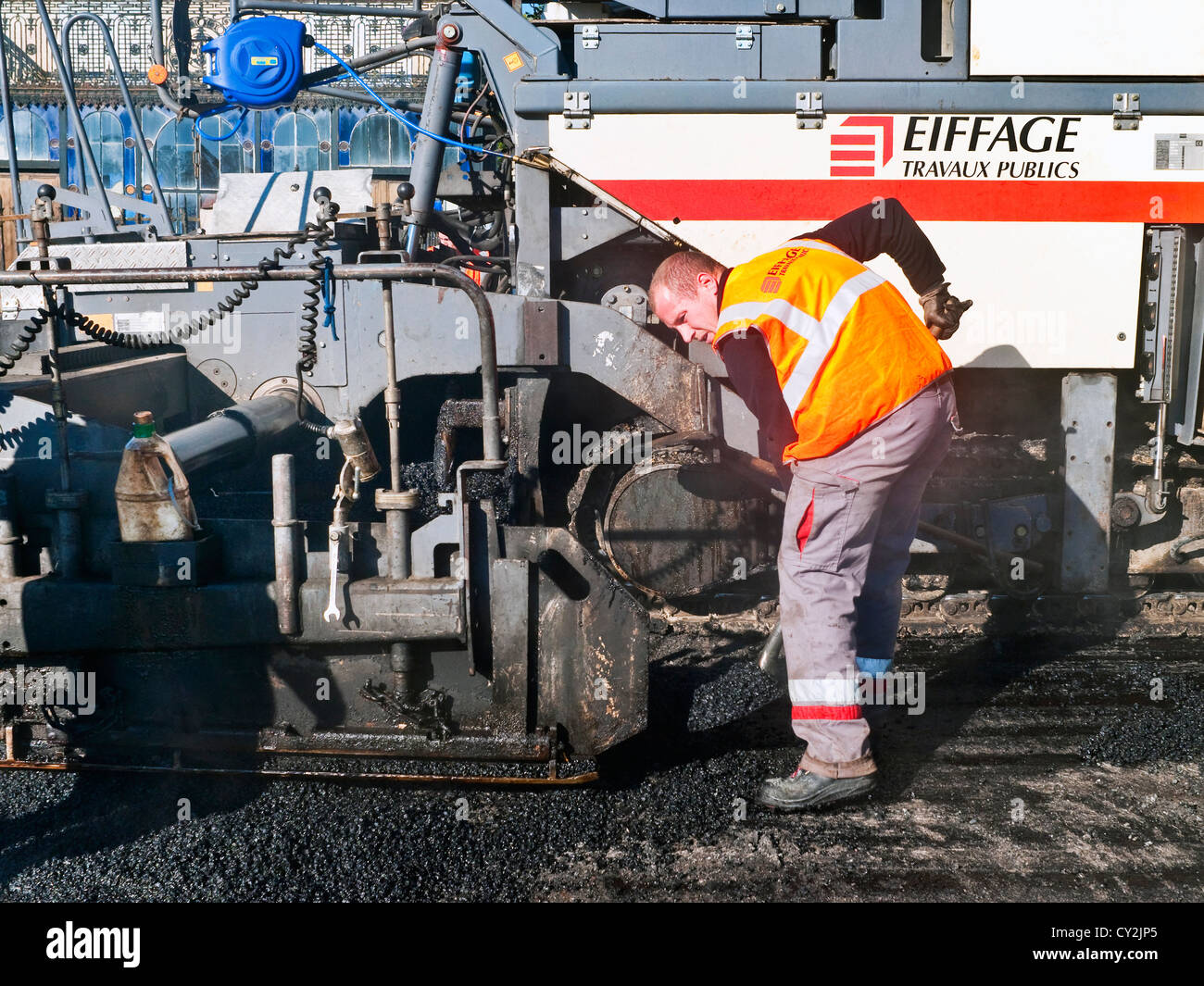 Workman spreading tarmac / tarmac laying machine in operation - France ...
