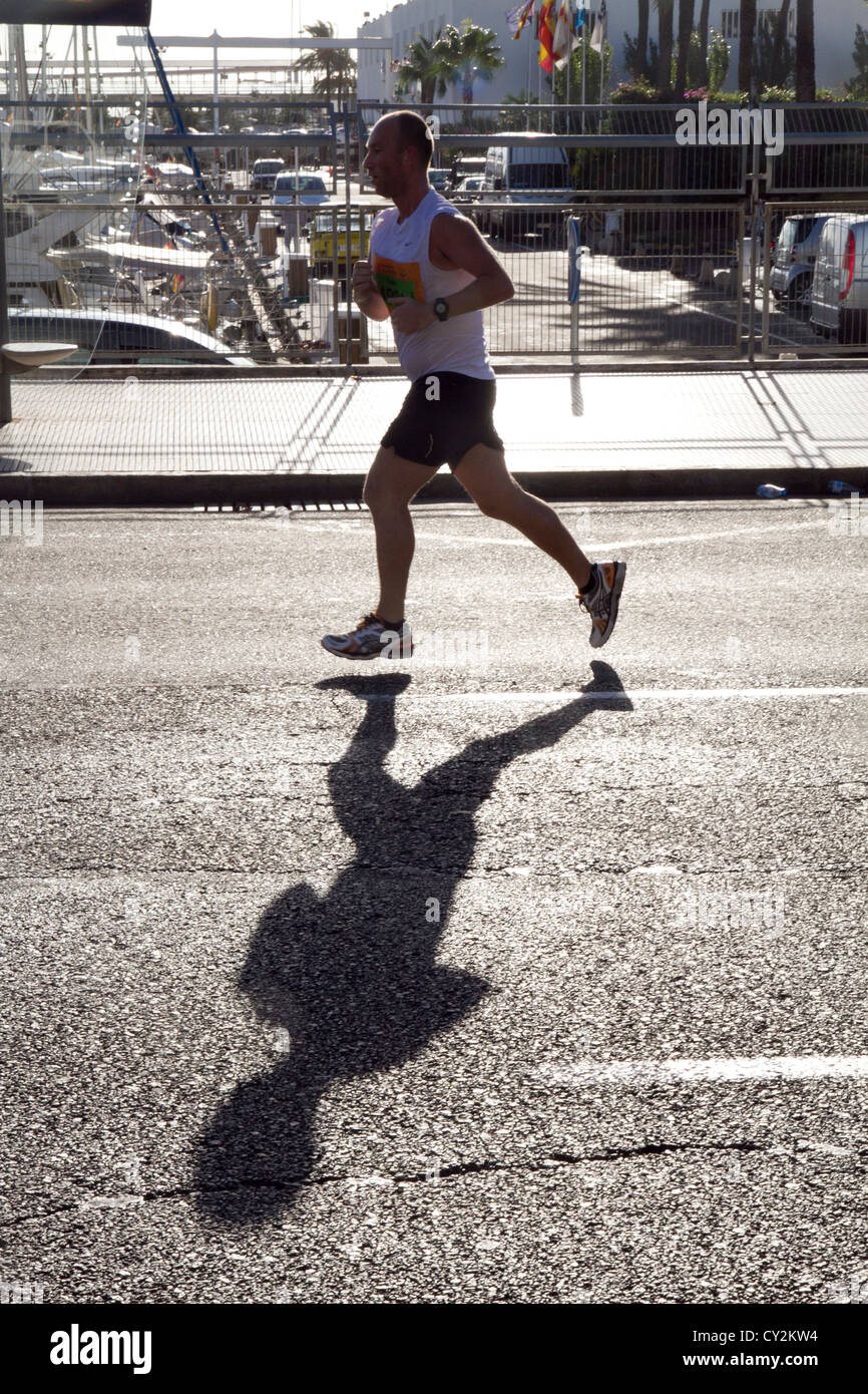 Marathon runner man shadow on road race athlete running Palma de ...