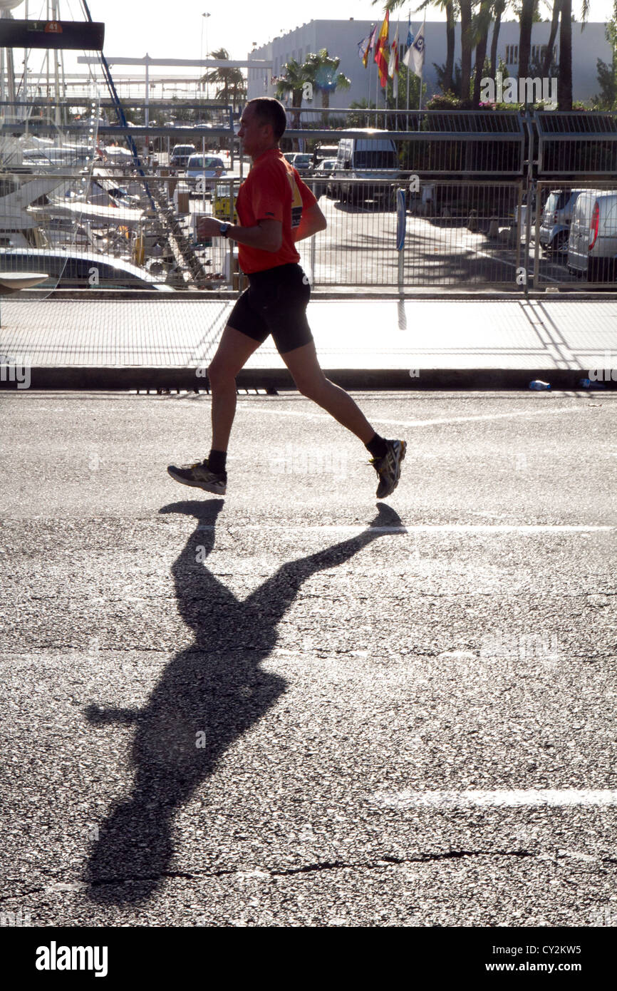 Marathon runner man shadow on road race athlete running Palma de ...