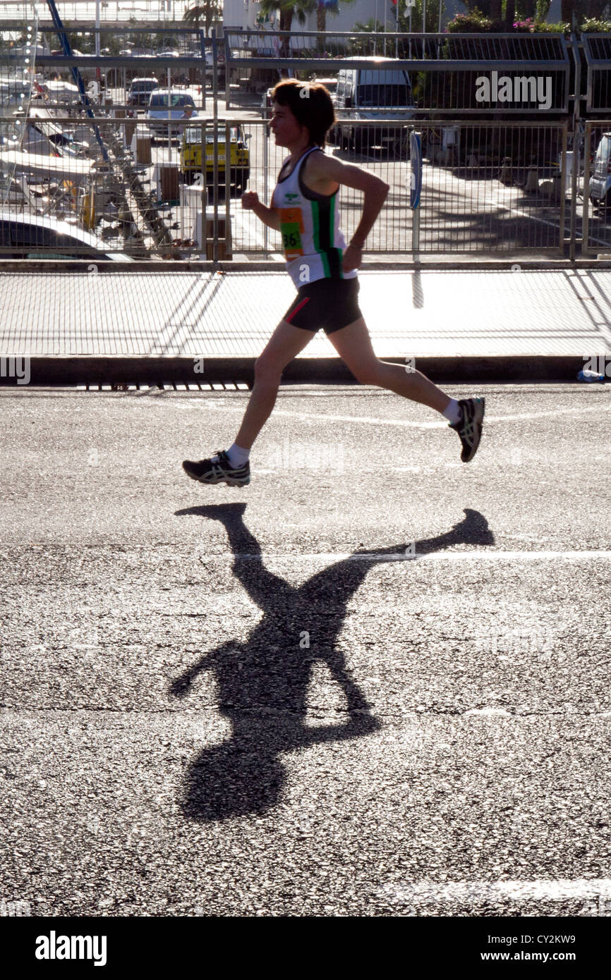 Marathon runner woman shadow on road race athlete running Palma de ...