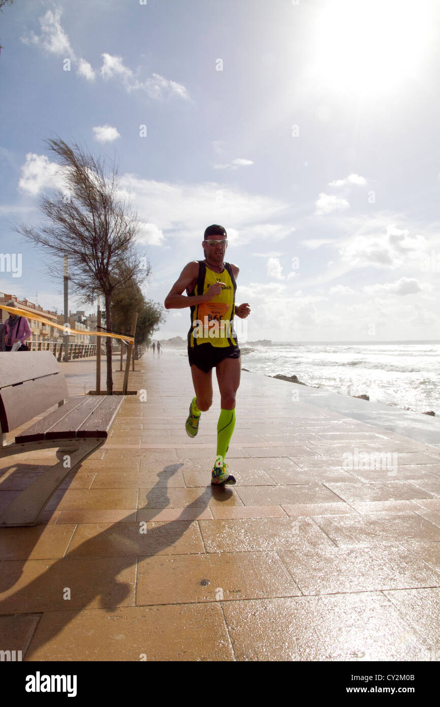 Marathon runner man race athlete running on promenade sea road Palma de ...