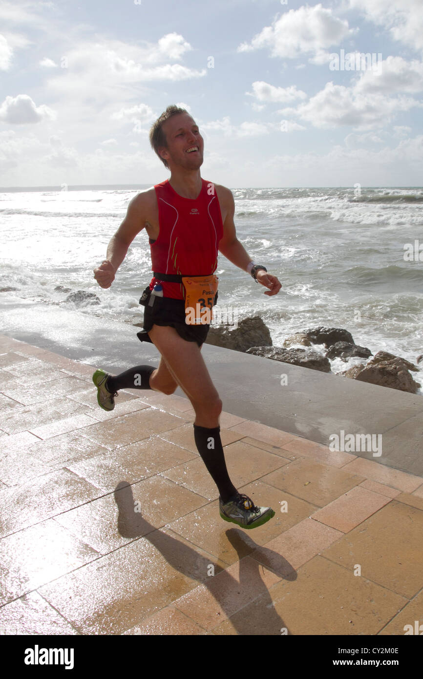 Marathon runner man race athlete running on promenade sea road Palma de ...