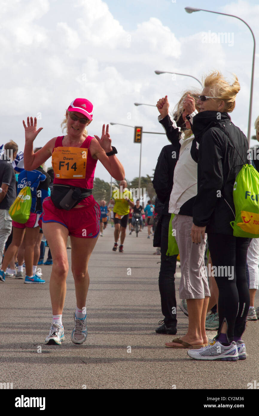 Marathon runner woman supporters race athletes running on road Palma de ...