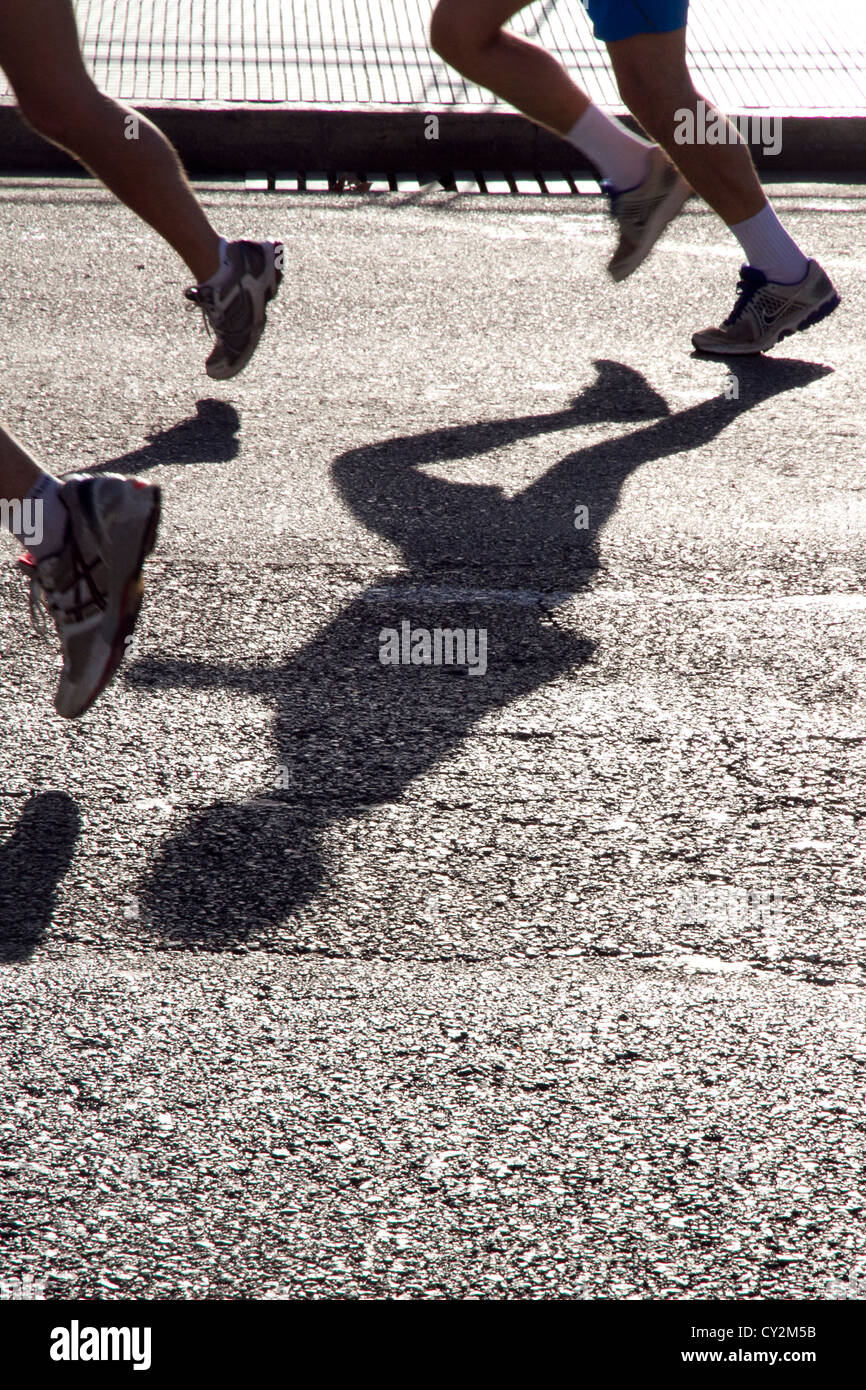 runners legs shadow on road athletes Marathon running Stock Photo - Alamy