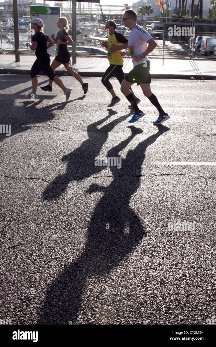 Marathon runners race athletes running shadows on road Palma de ...