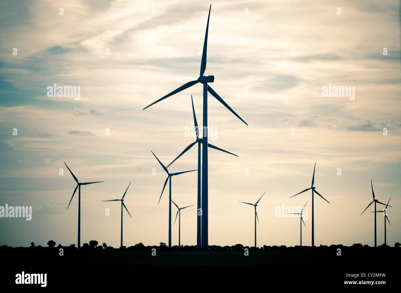 Backlit view of a group of mills for electric power generation Stock ...