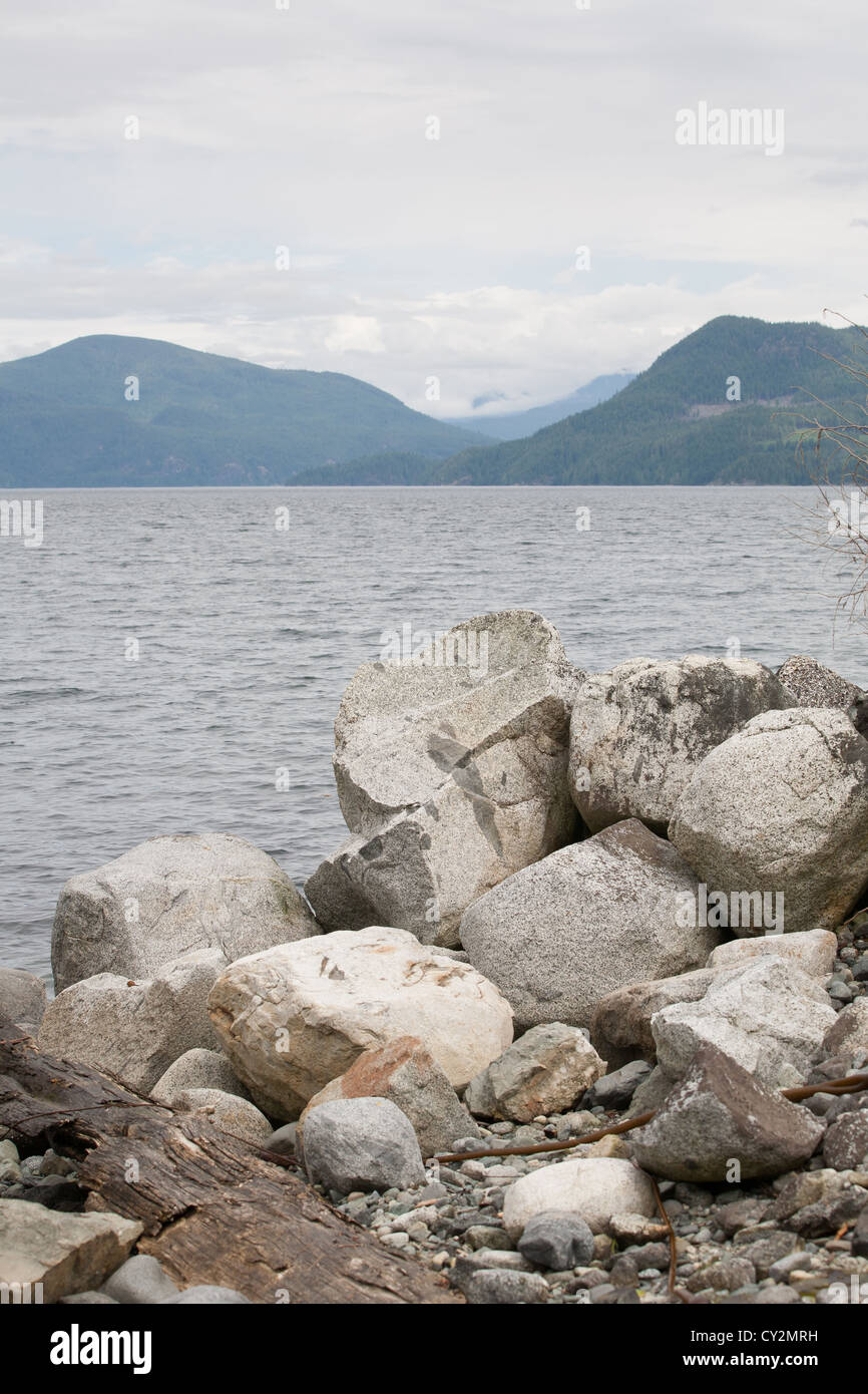 Large rocks sit by the ocean side on a beach Stock Photo - Alamy