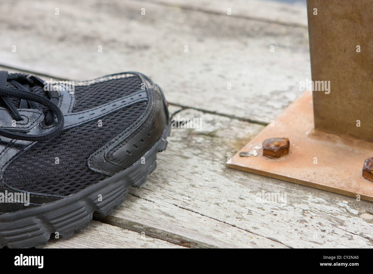 A trainer next to a rusted iron post Stock Photo - Alamy