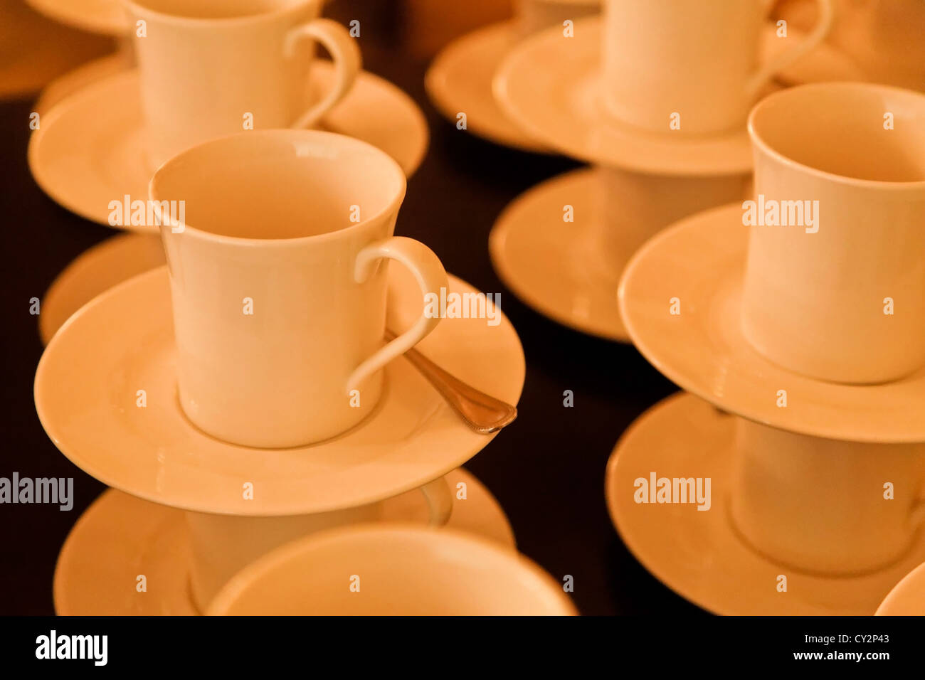 Display of lined up Cups and Saucers with teaspoons ready for service ...