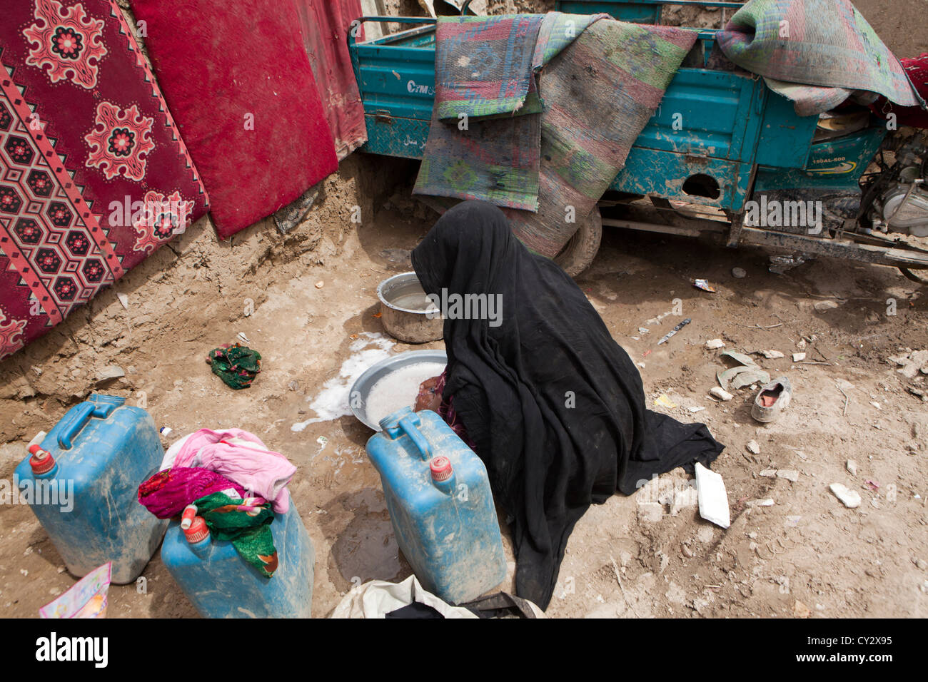 Afghan woman doing laundry in a slum area Stock Photo - Alamy