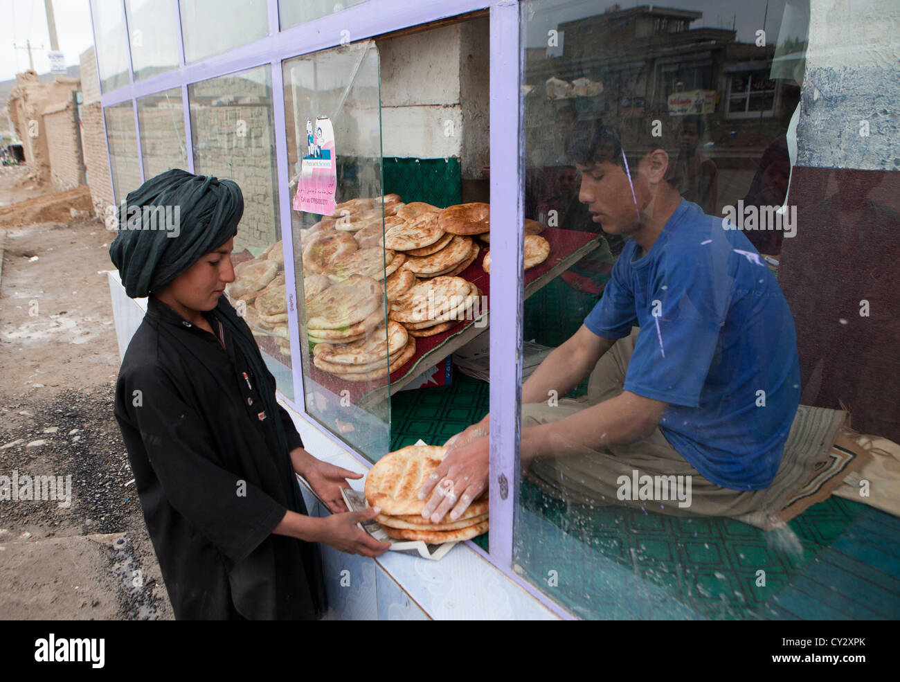 Afghan kid buys bread at the bakery Stock Photo - Alamy