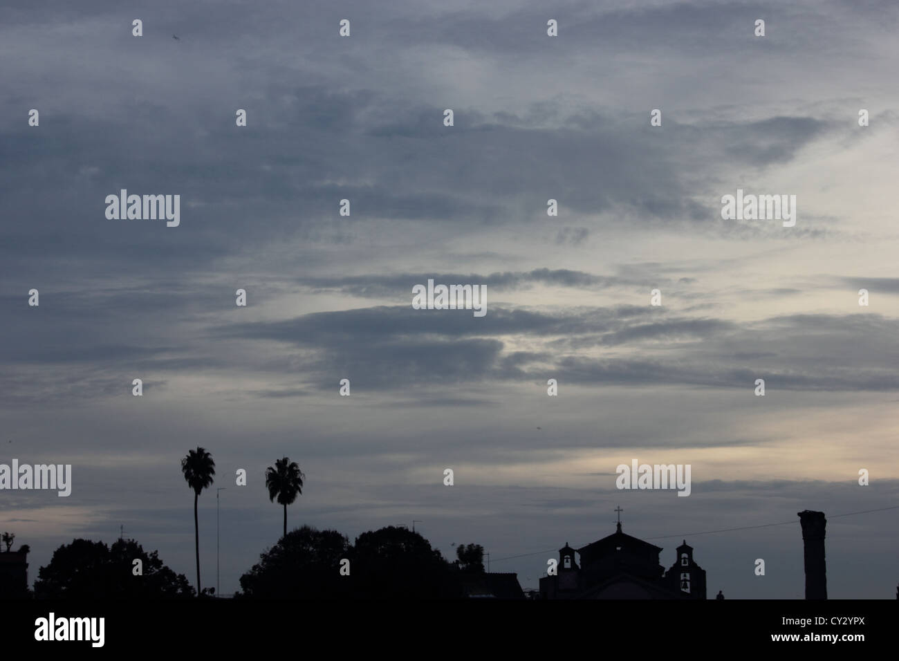 Silhouettes of Rome's sky line against a beautiful cloudy sky at dusk ...